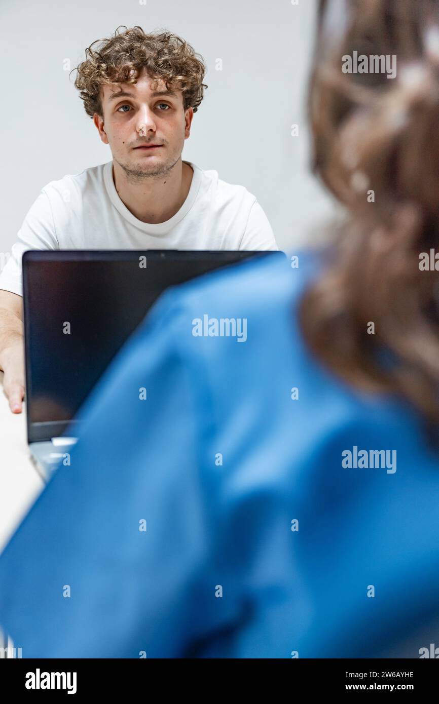 Anonymous female doctor in uniform while sitting at table with laptop ...