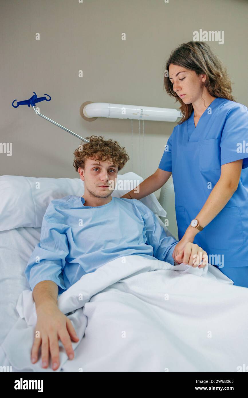 Young female doctor checking patient sitting on bed in hospital while ...
