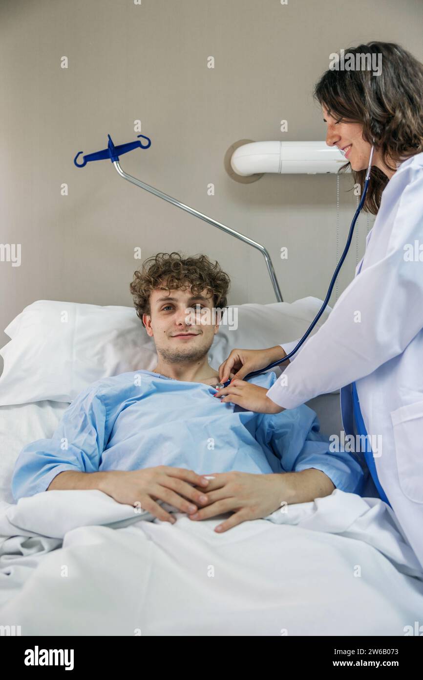 Side view of happy doctor checking heartbeat with stethoscope on ...