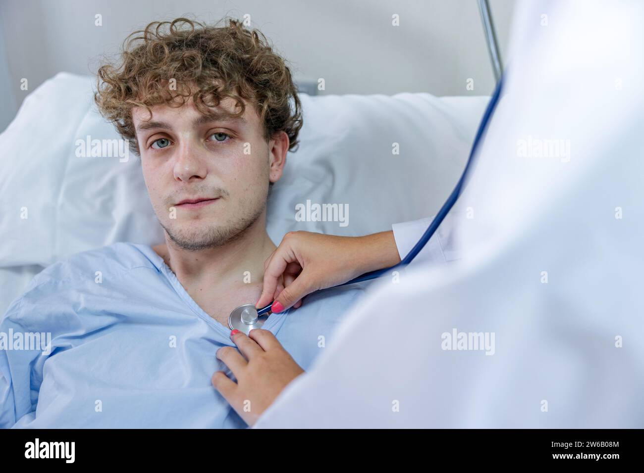 Anonymous doctor checking heartbeat with stethoscope on patient lying ...