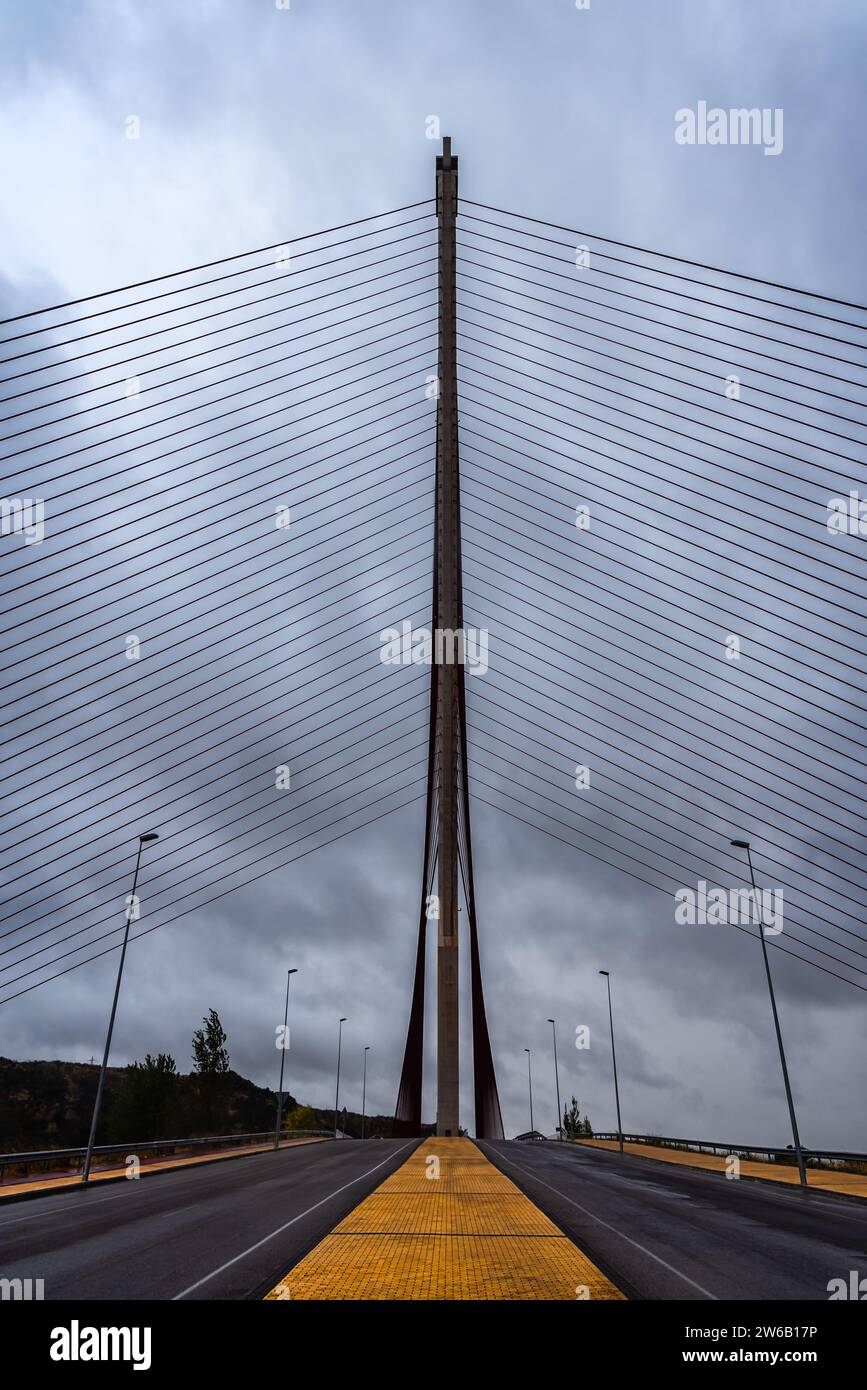 A perspective view of a modern cable-stayed bridge with red cables on ...