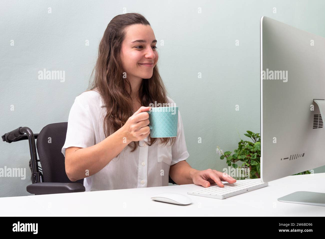 A content woman in wheelchair enjoys a warm drink while engaging with ...