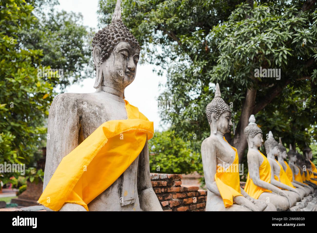 Stone Buddha statues in lotus pose covered with sacred traditional ...