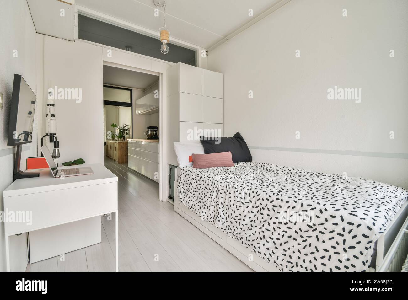 A neatly organized studio apartment featuring a comfortable bed with ...