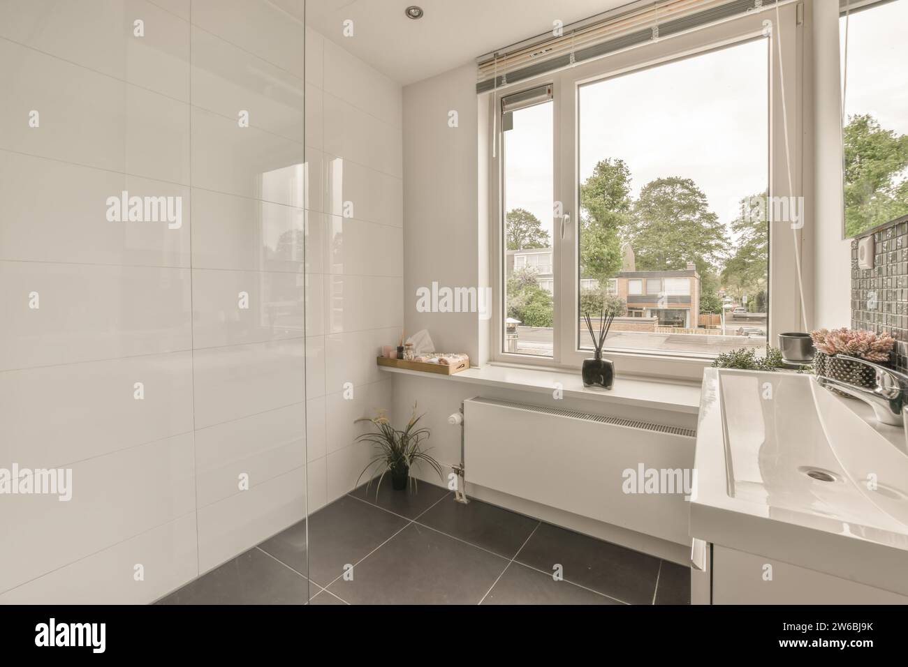 Spacious bright white contemporary bathroom with shower booth glass and ...