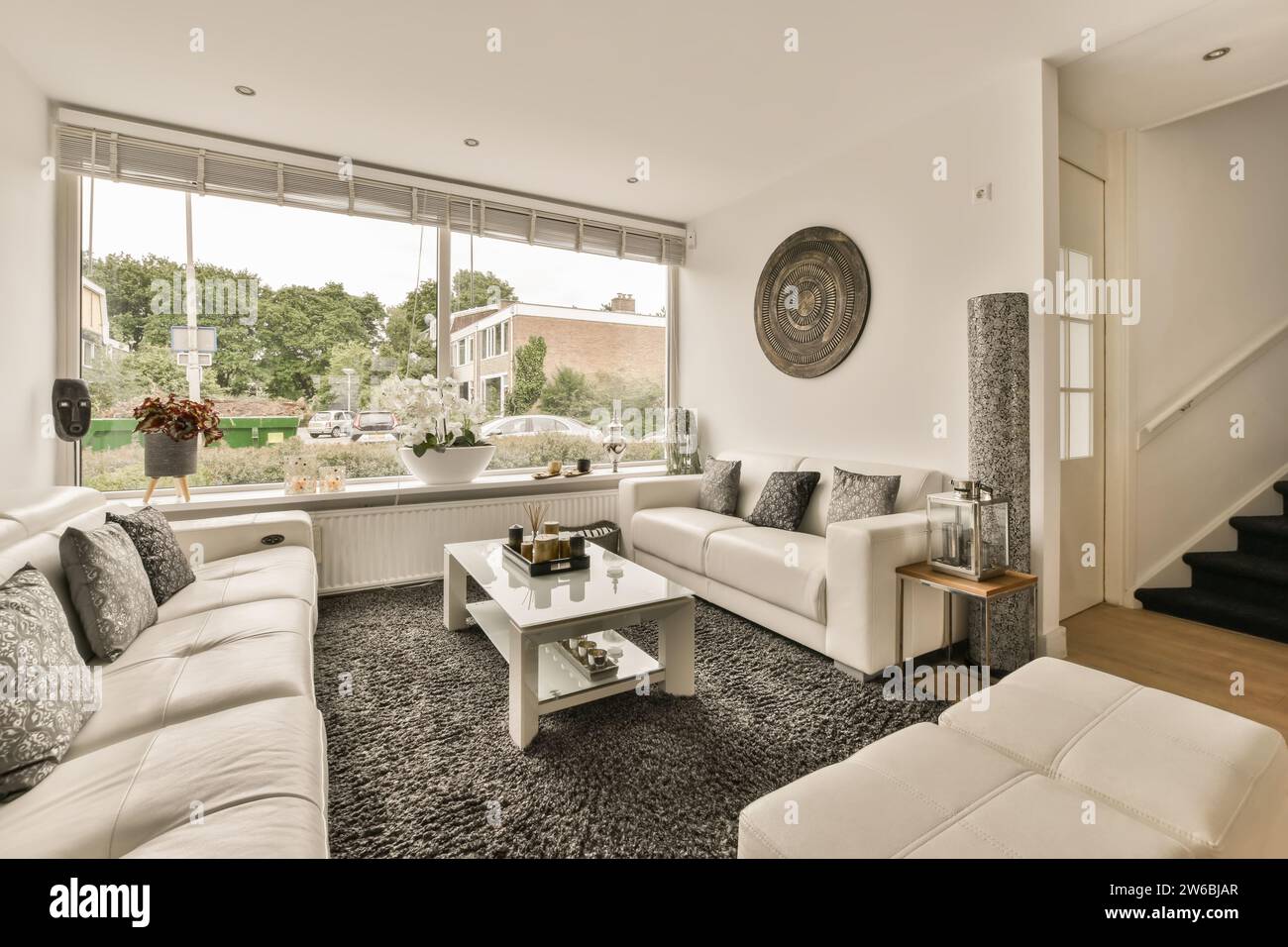 Decor on window sill by sofa and coffee table on carpet in spacious ...