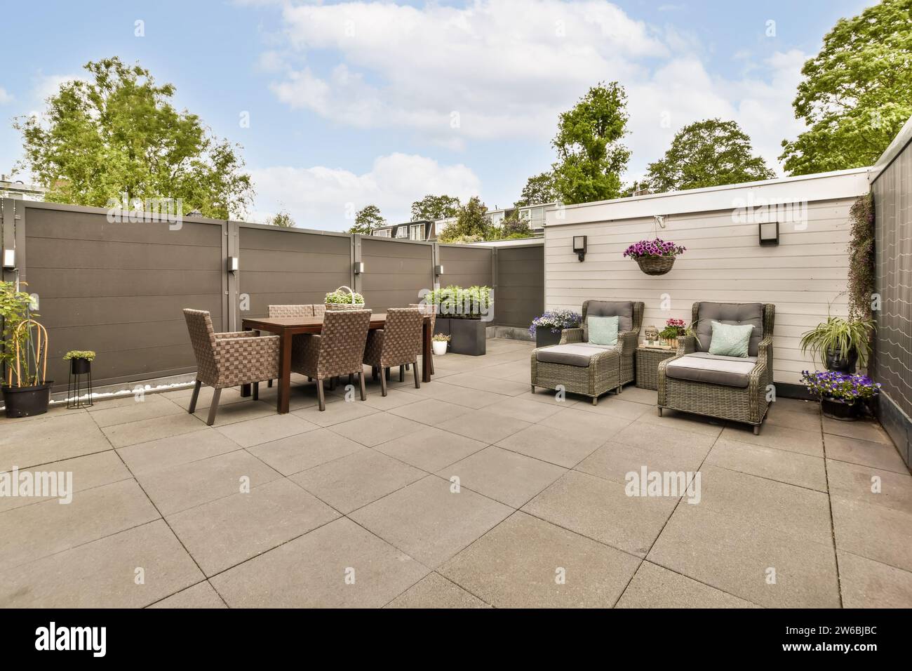 Wicker lounge chairs by dining table with flower plant decorations in ...