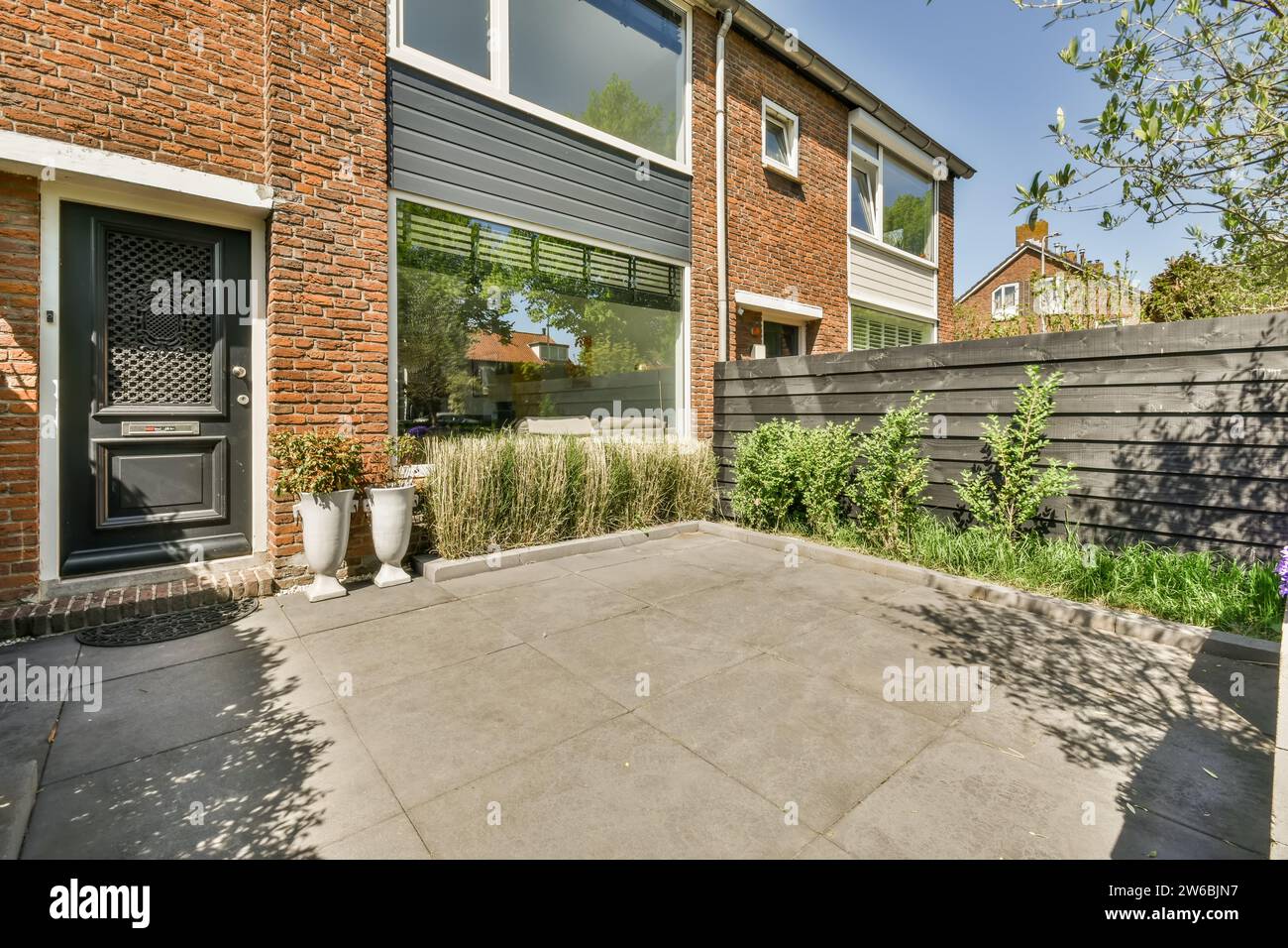 Empty backyard veranda with plants and planters by fence with closed ...