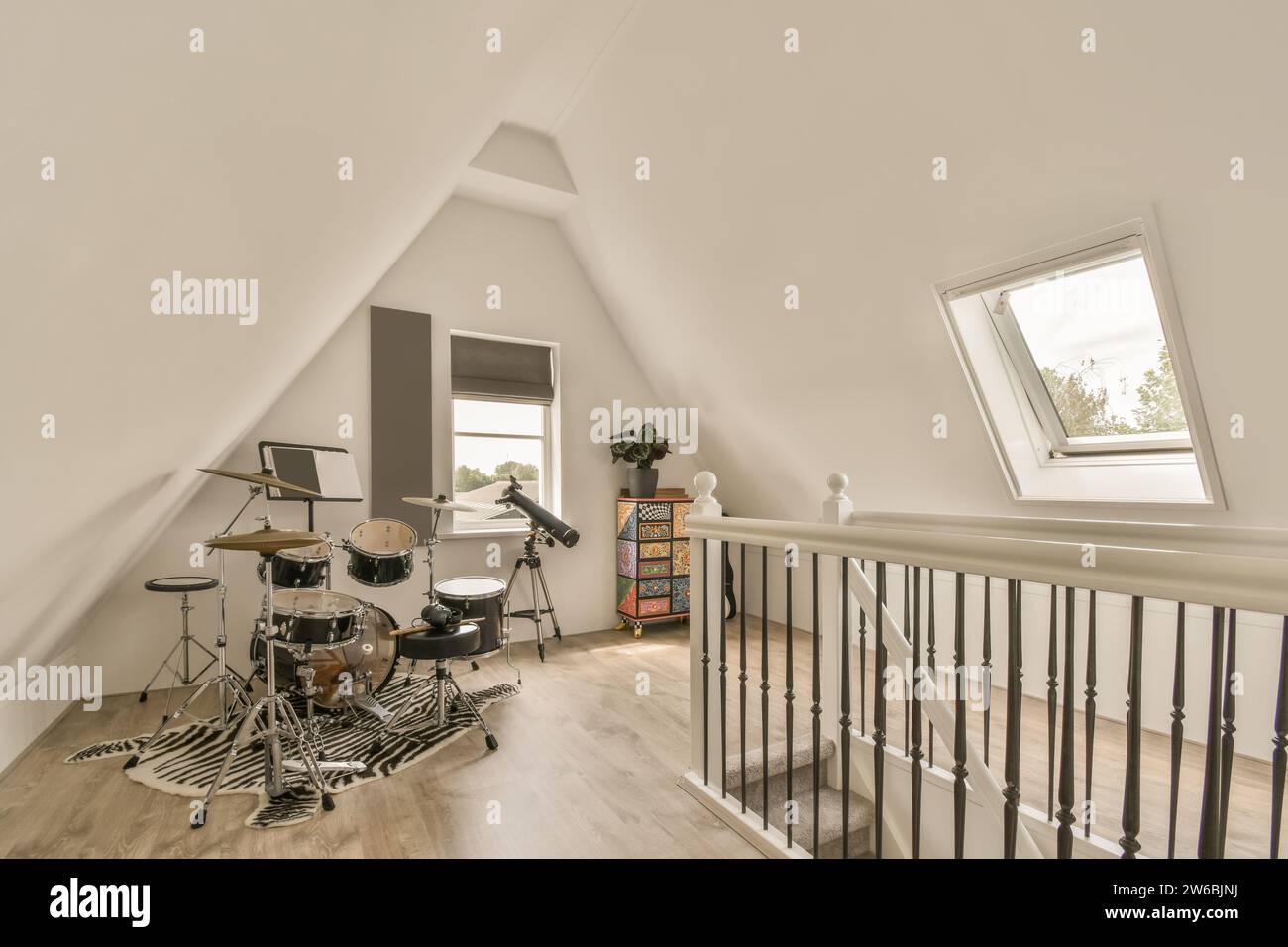 Spacious white loft with drum set and cabinet with windows and ...