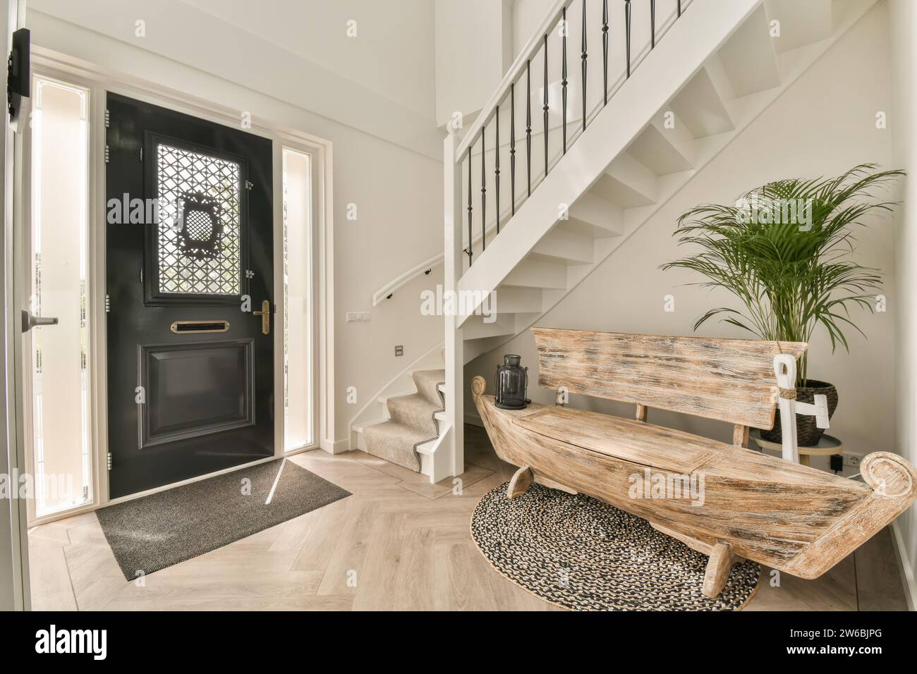 Entrance foyer with closed door by staircase above wooden boat shaped ...