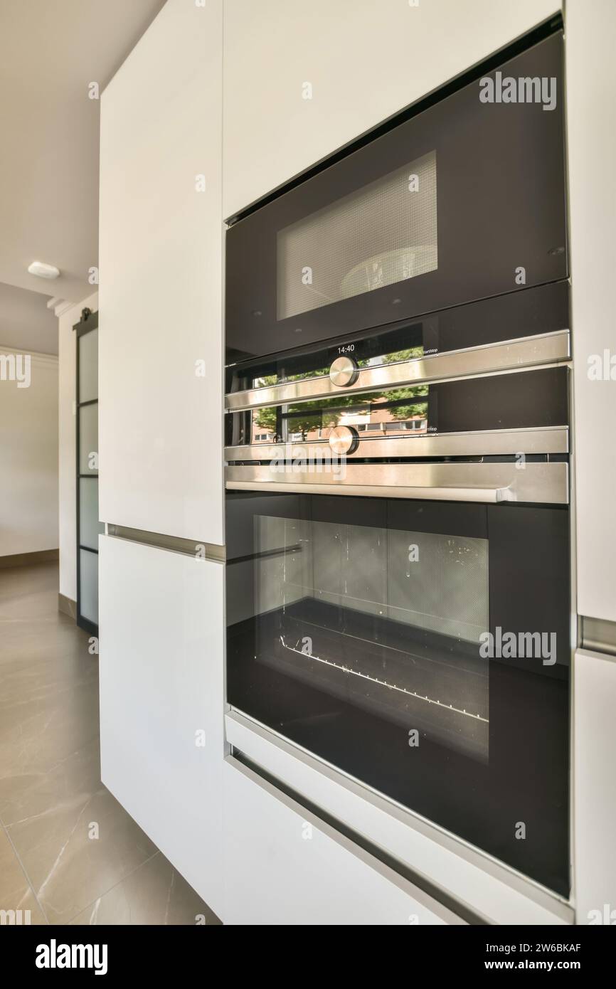 A vertical shot of contemporary built-in kitchen ovens with a ...