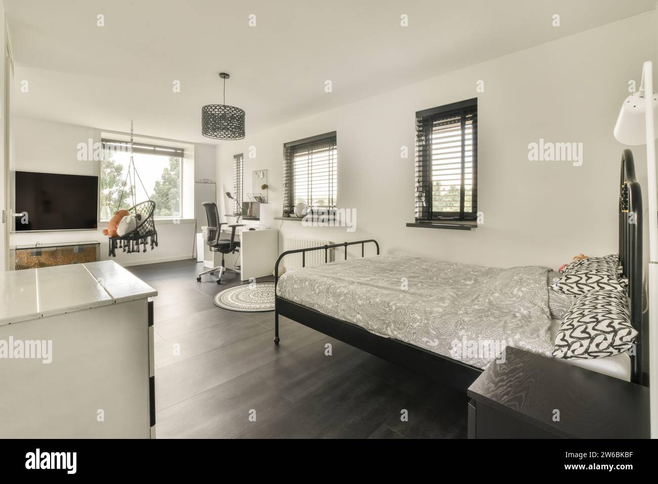 A well-lit modern bedroom featuring a comfortable bed, contemporary ...