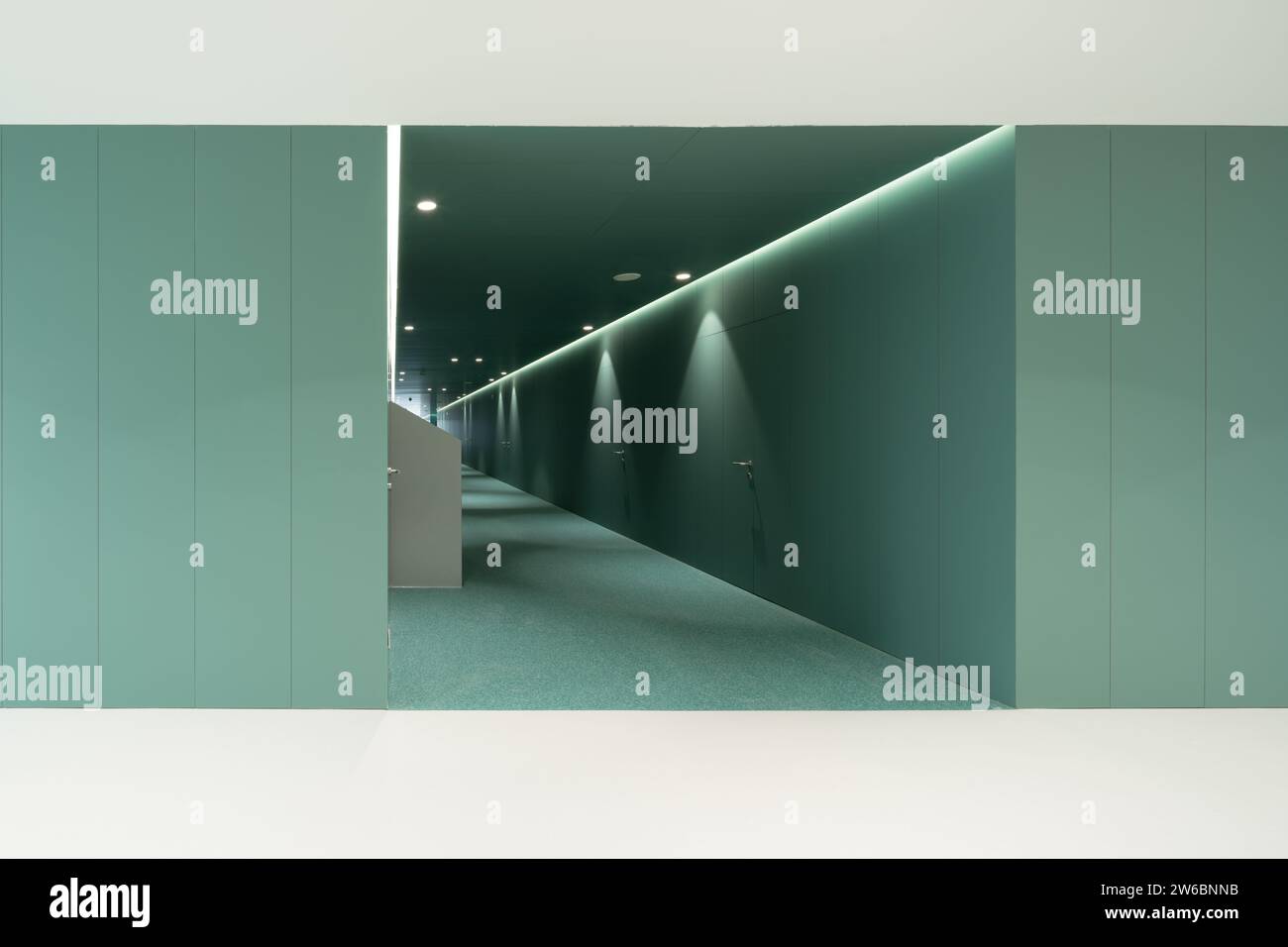 Interior of illuminated green passage with green doors and walls in ...