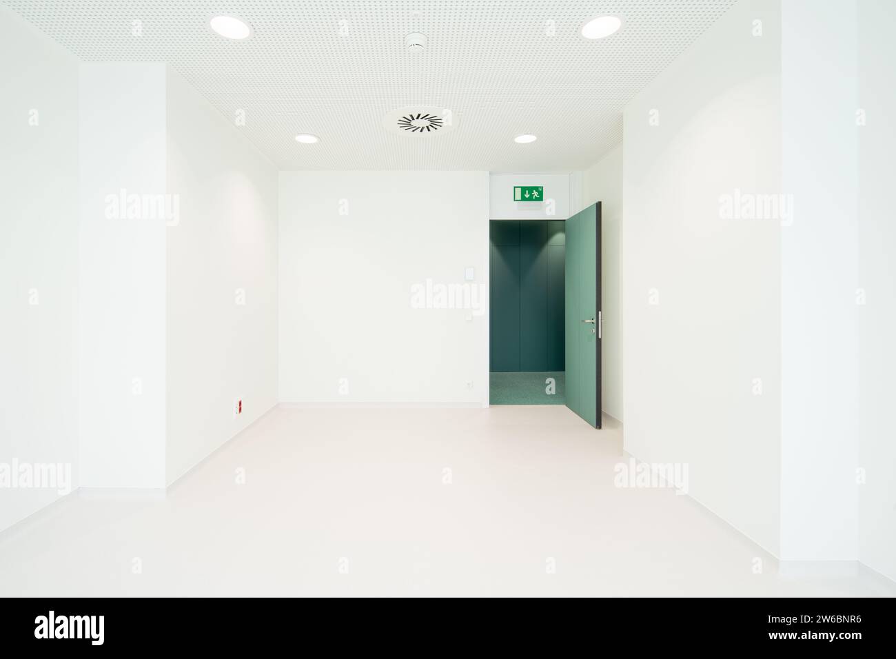 Interior of bright white room with green open door in modern hospital ...