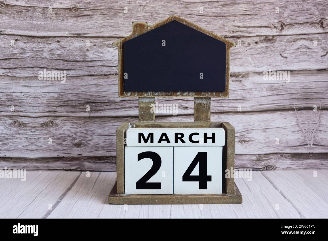 Chalkboard with March 24 calendar date on white cube block on wooden ...
