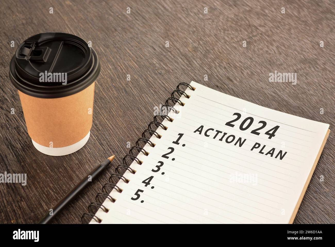 2024 Action Plan text on Notepad with disposable coffee cup on wooden ...