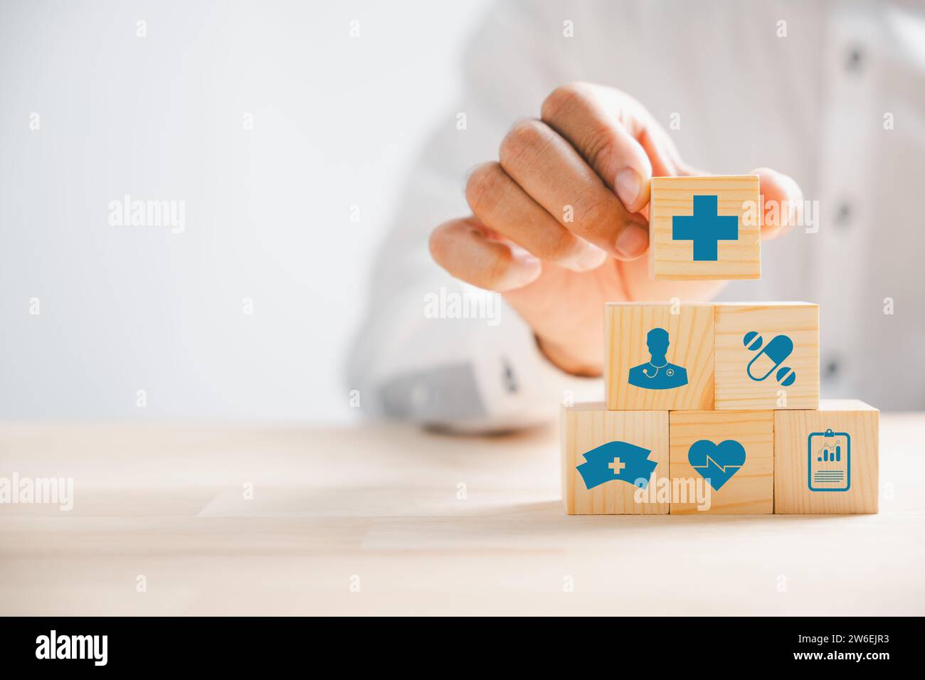 Hand hold wooden block with icon healthcare medical Stock Photo - Alamy