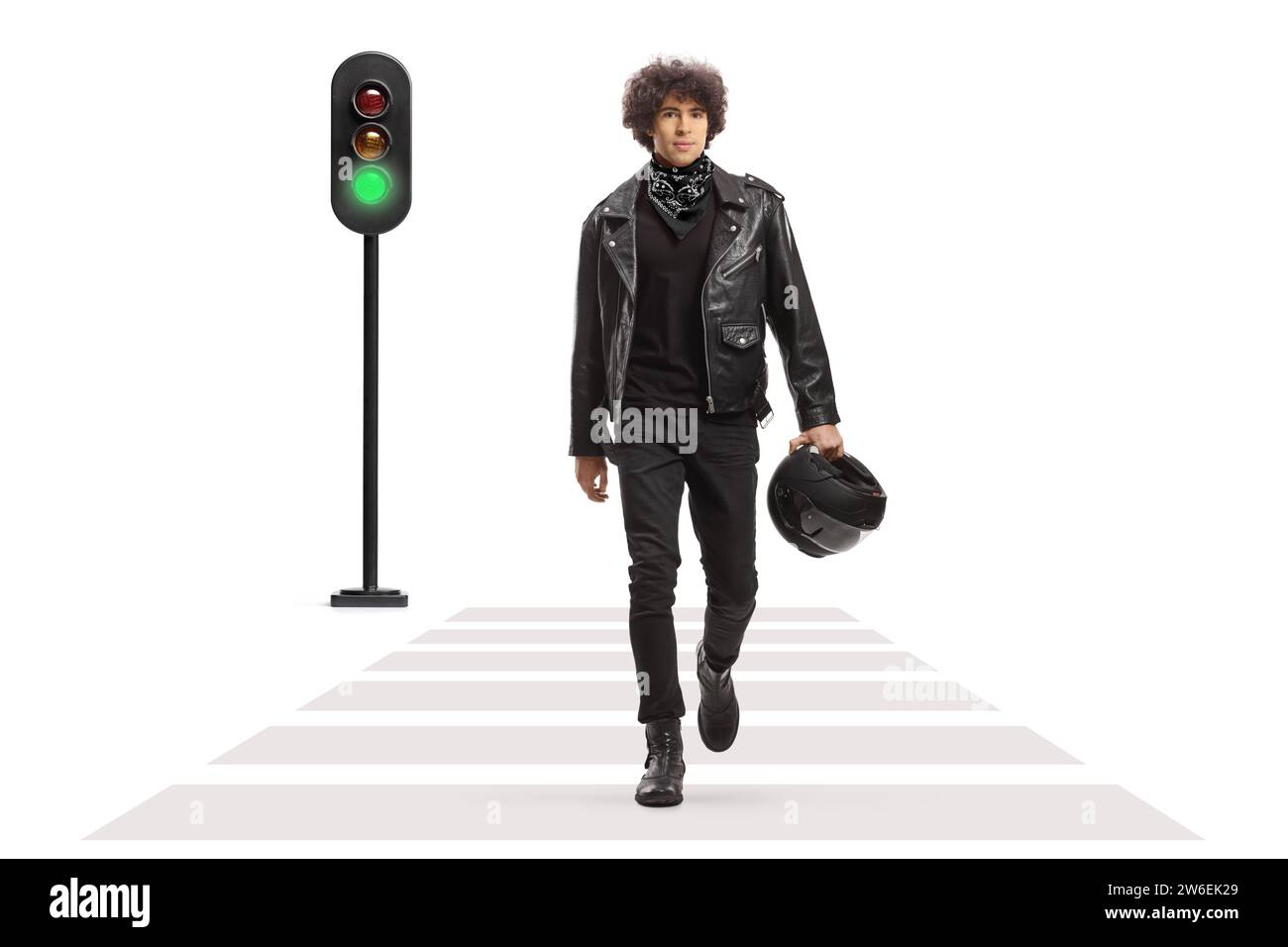 Full length portrait of a young man carrying a helmet and crossing a ...