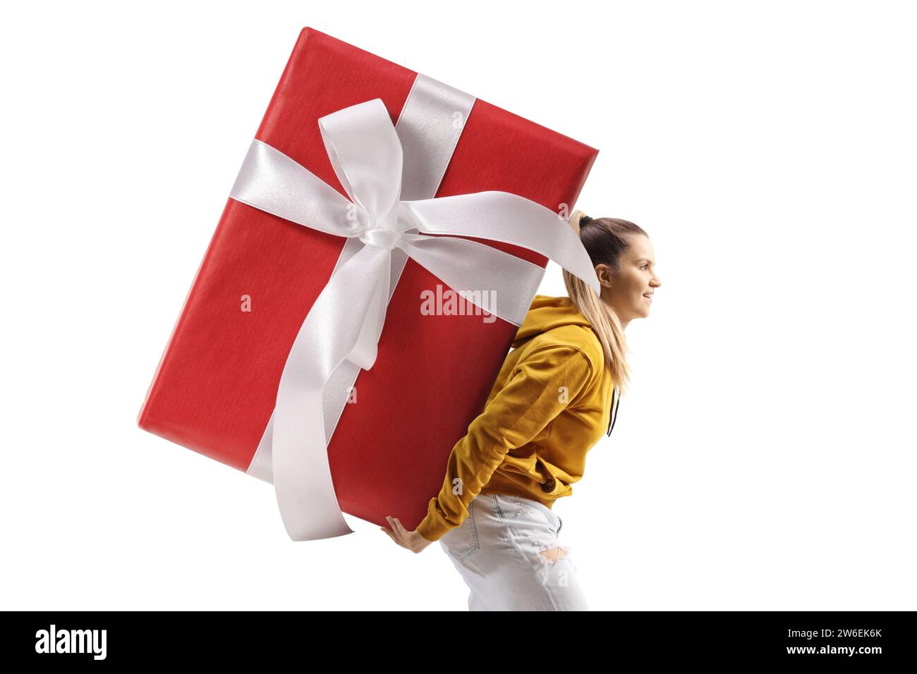 Young female carrying a big wrapped present on her back isolated on ...