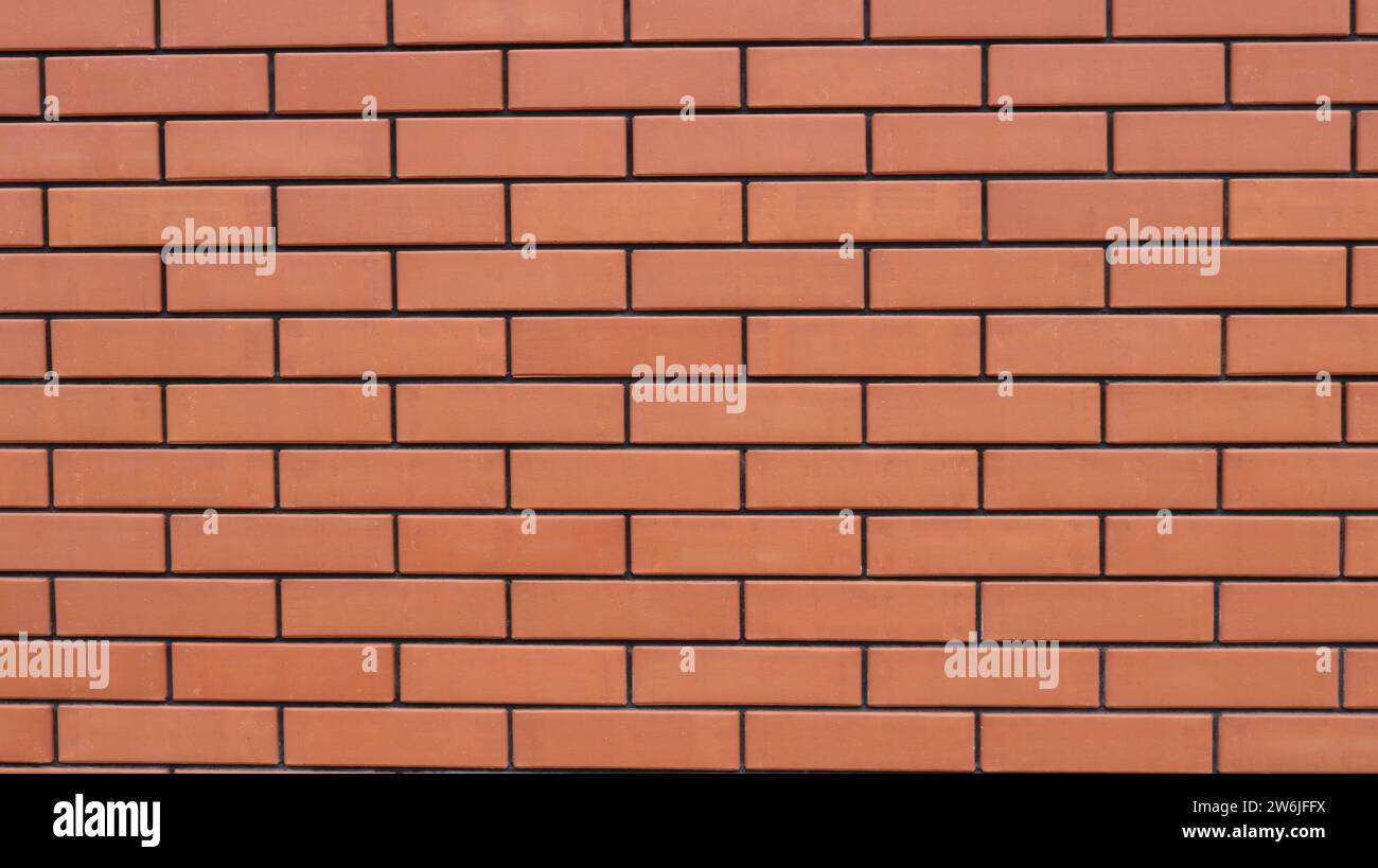 smooth brick wall in a pale orange hue with dark seams between ...
