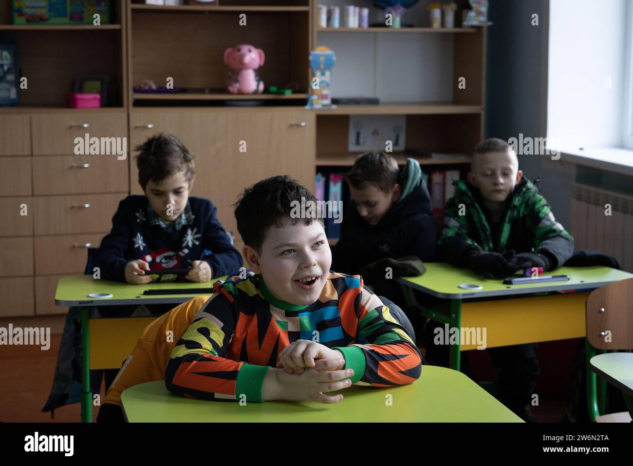 Children sit on their desks at a rural school classroom before the ...