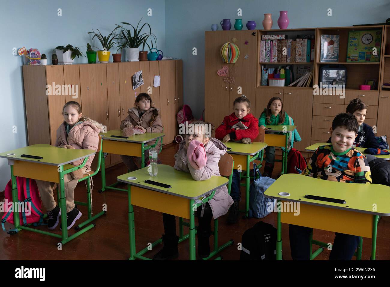 Children sit on their desks at a rural school classroom before the ...