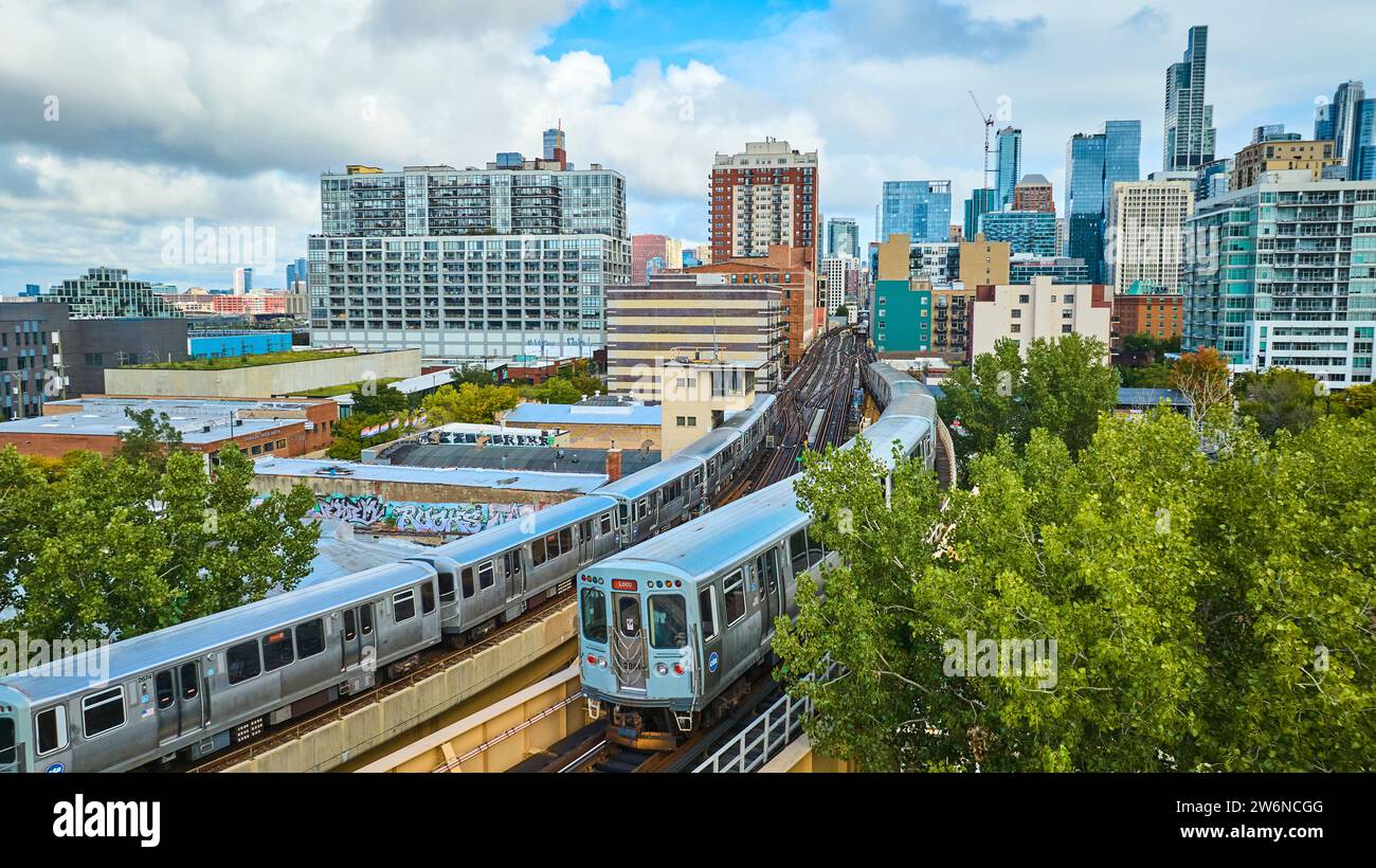 Trains on train track in Chicago aerial with big city skyscrapers in ...