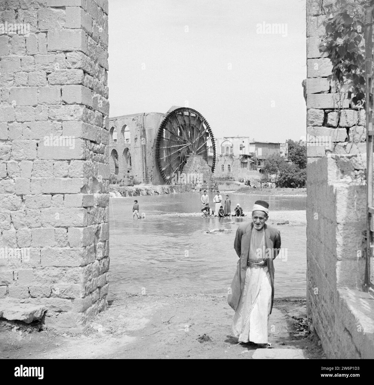 Wooden water wheel on the Orontes in Hama. Children playing in the ...