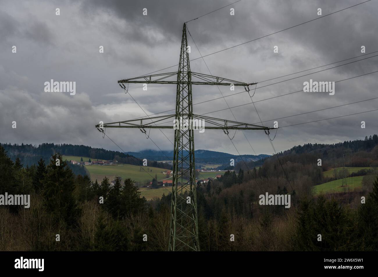 High-voltage pylon in rural landscape with dark clouds before a storm ...