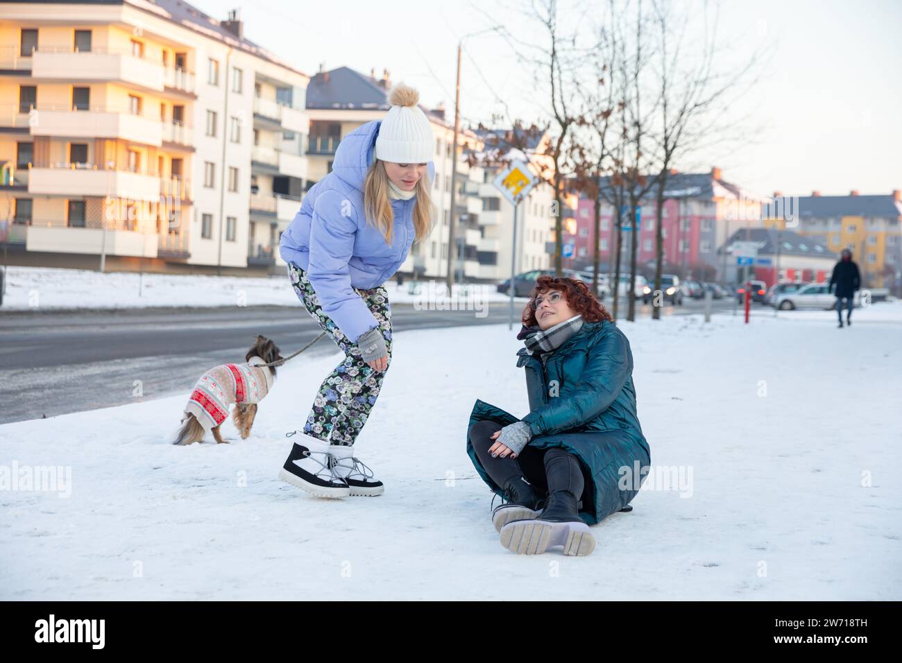 A passerby with a dog tries to help a woman get up Stock Photo - Alamy