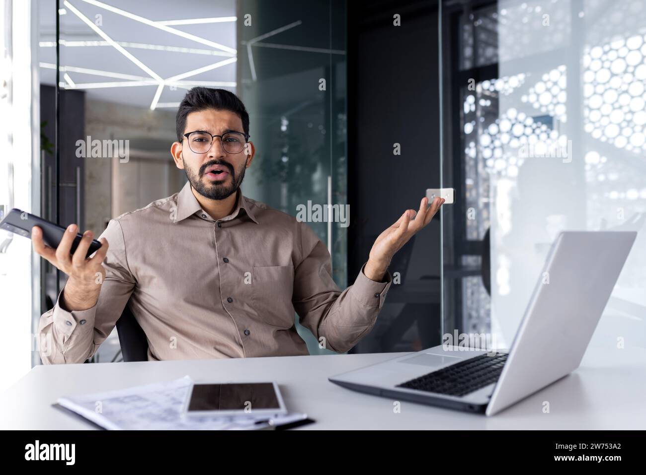 Portrait of a young angry and disappointed Indian man sitting at an ...