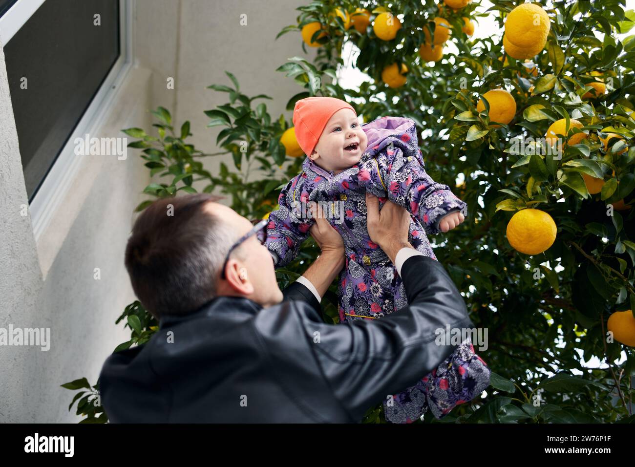 A young father lifts his little daughter above his head Stock Photo - Alamy