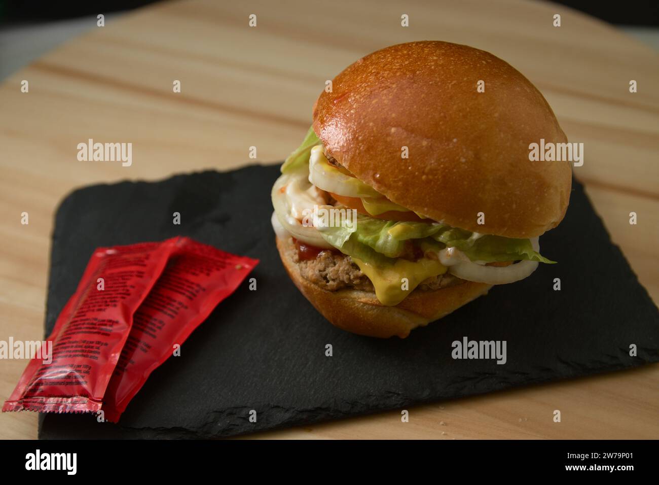 Homemade burger with meat, onion, lettuce, tomato and various sauces ...