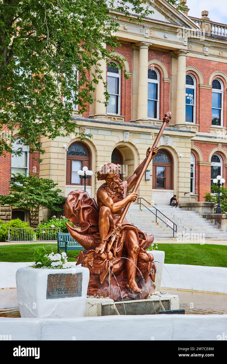 Bronze Poseidon statue in fountain outside Elkhart County courthouse on summer day, law and ...