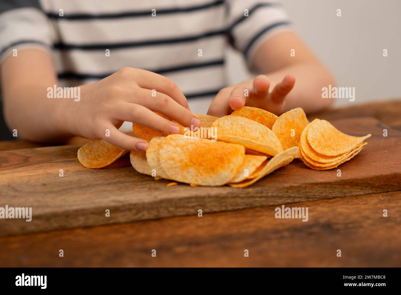 Child stacking crispy potato chips, casual snack on rustic wood Stock ...