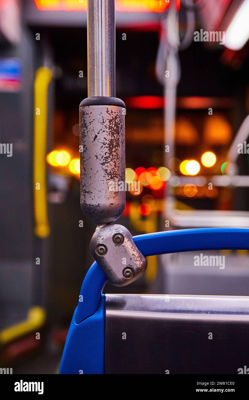 Railing, handlebar in bus at night close up, colorful blurred city ...