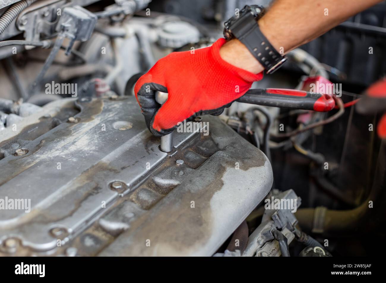 Repairing a car. An auto mechanic unscrews the gas distribution ...
