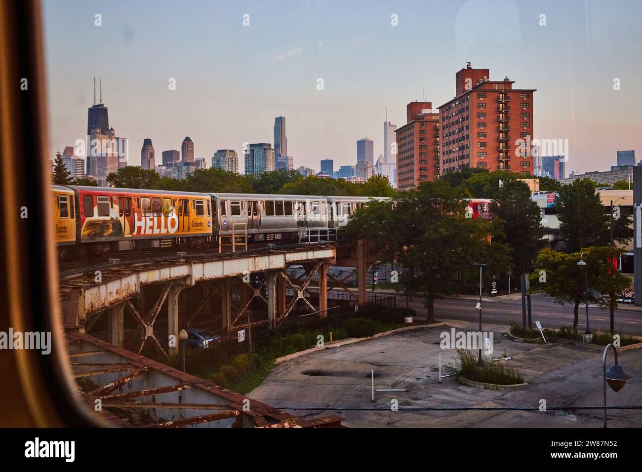 Train on raised track curving beside empty parking lot with Chicago ...