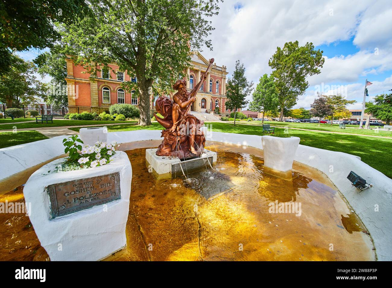 Poseidon bronze statue in golden yellow water fountain in front of Elkhart County courthouse ...