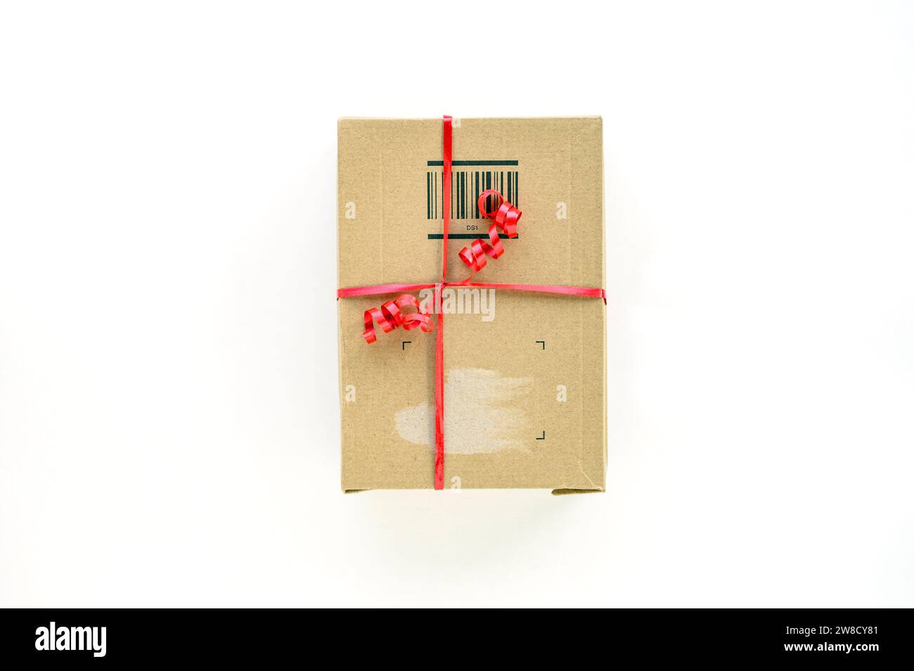 Christmas gift parcel in it's original package with a red ribbon tied ...