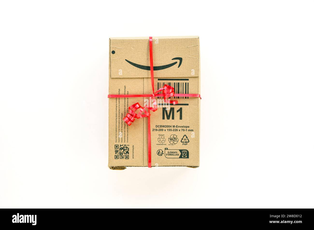 Christmas gift parcel in it's original package with a red ribbon tied ...