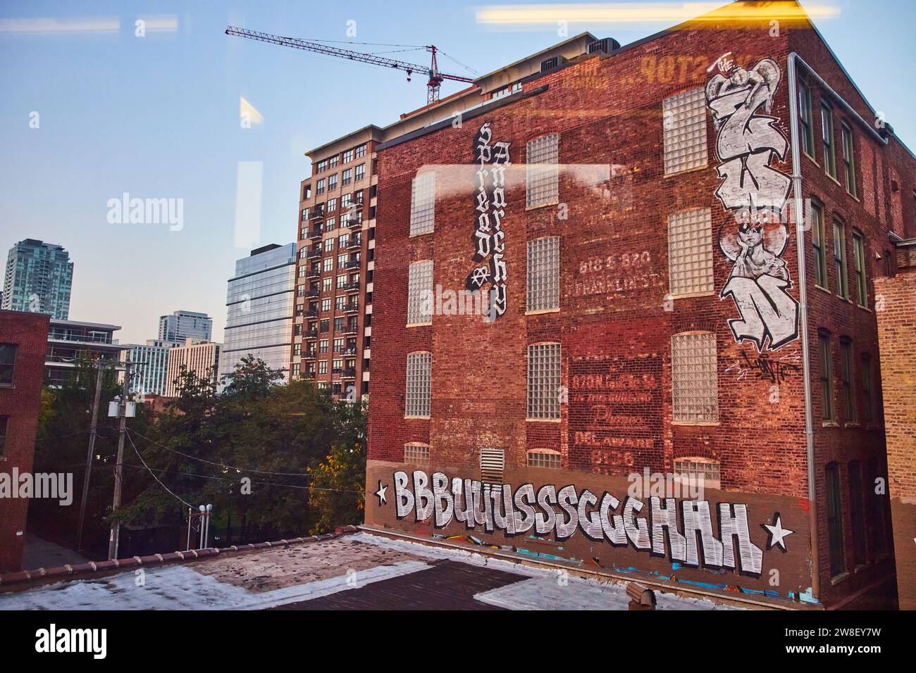 Graffiti on red brick building with construction crane in Chicago ...