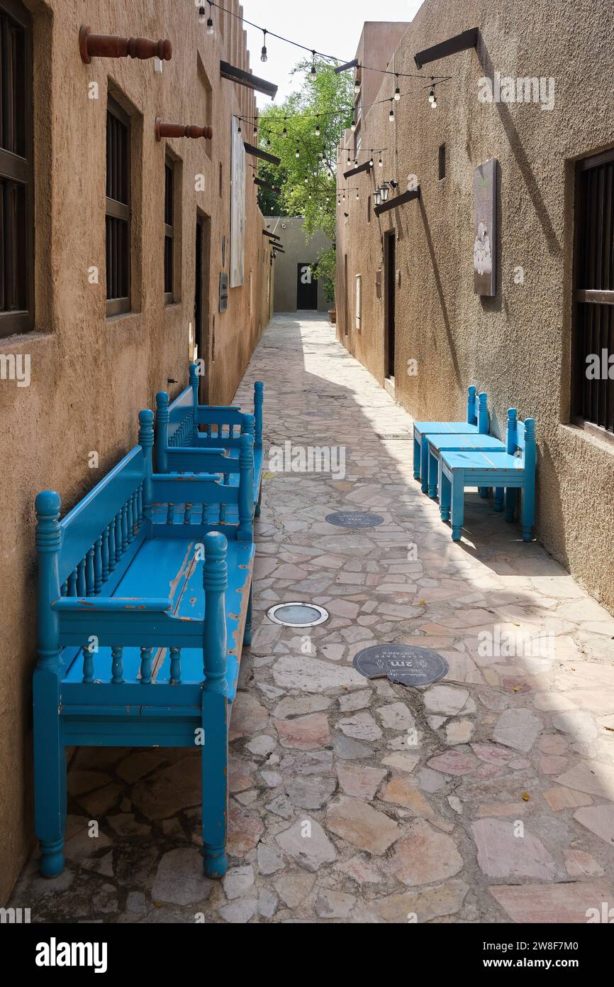 Weathered blue wooden benches and seats in a side street in the Al ...