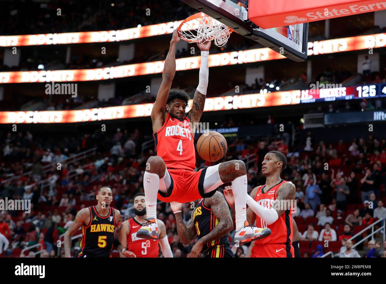 Houston Rockets guard Jalen Green (4) hangs on the rim after dunking ...