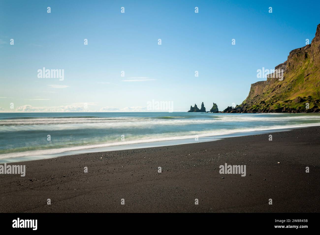 Black sand beach with Reynisdrangar basalt sea stacks and cliffs in ...