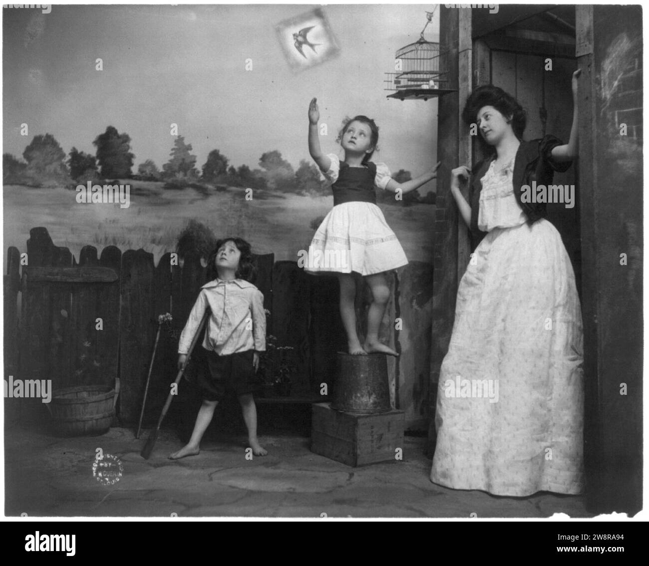 Woman and 2 children watching bird fly from cage Stock Photo - Alamy