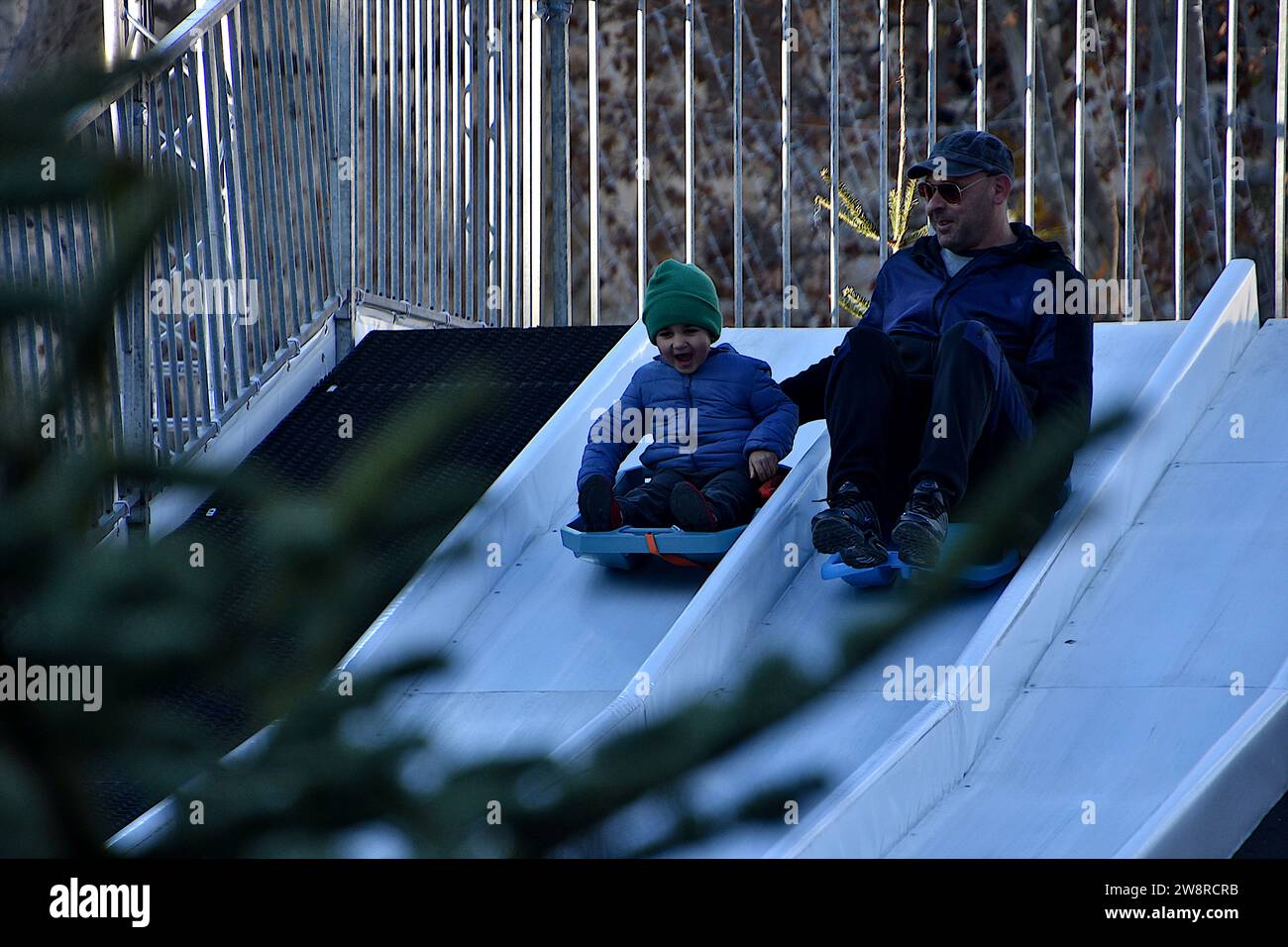 A father and his child slide down a synthetic toboggan run. For the end ...