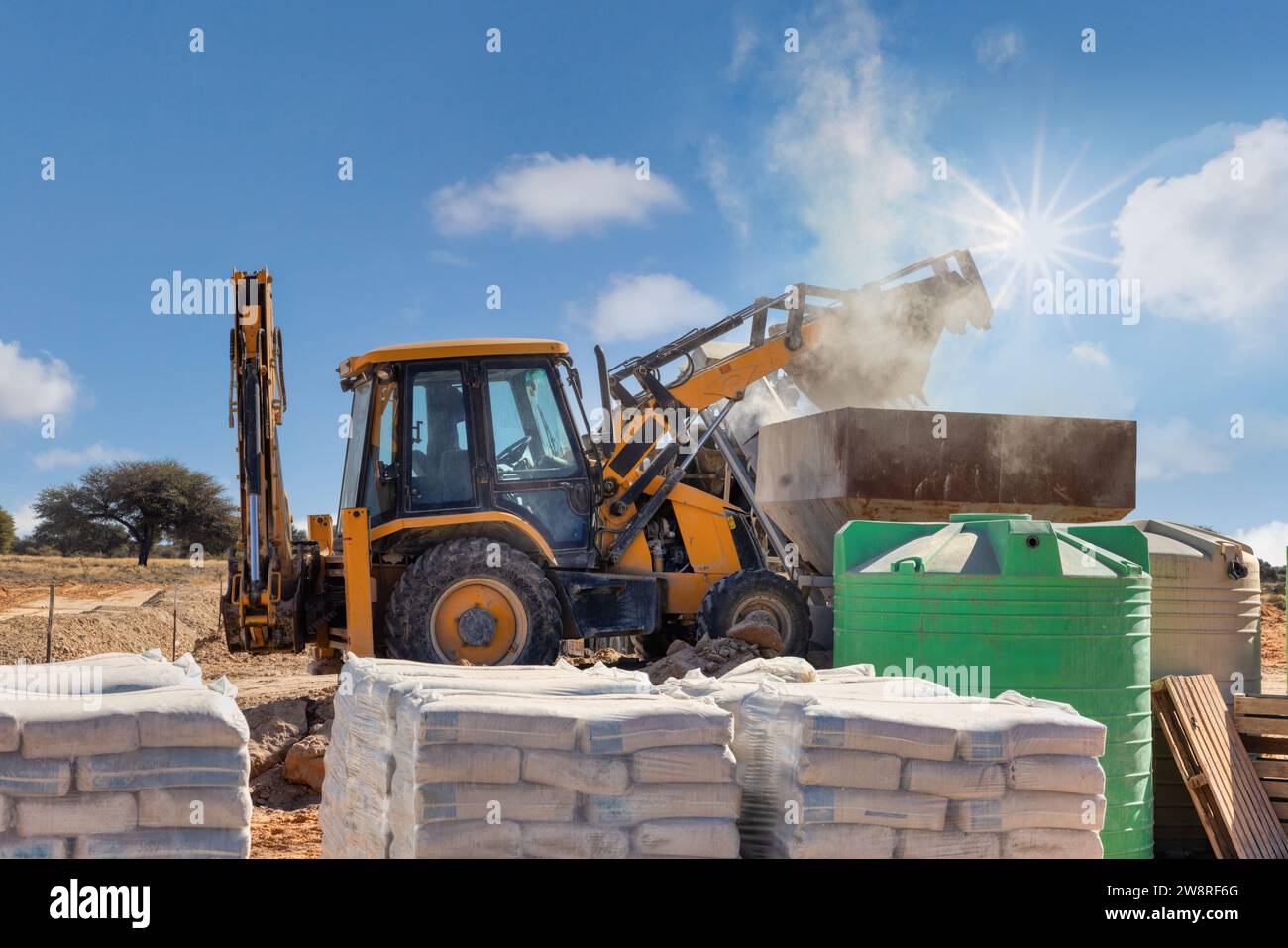 backhoe, on the construction site, loading a truck, cement in the front ...