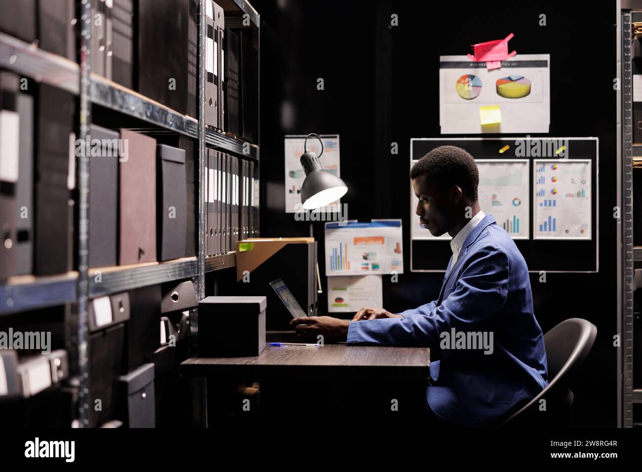 African american police officer analyzing investigation files, working ...