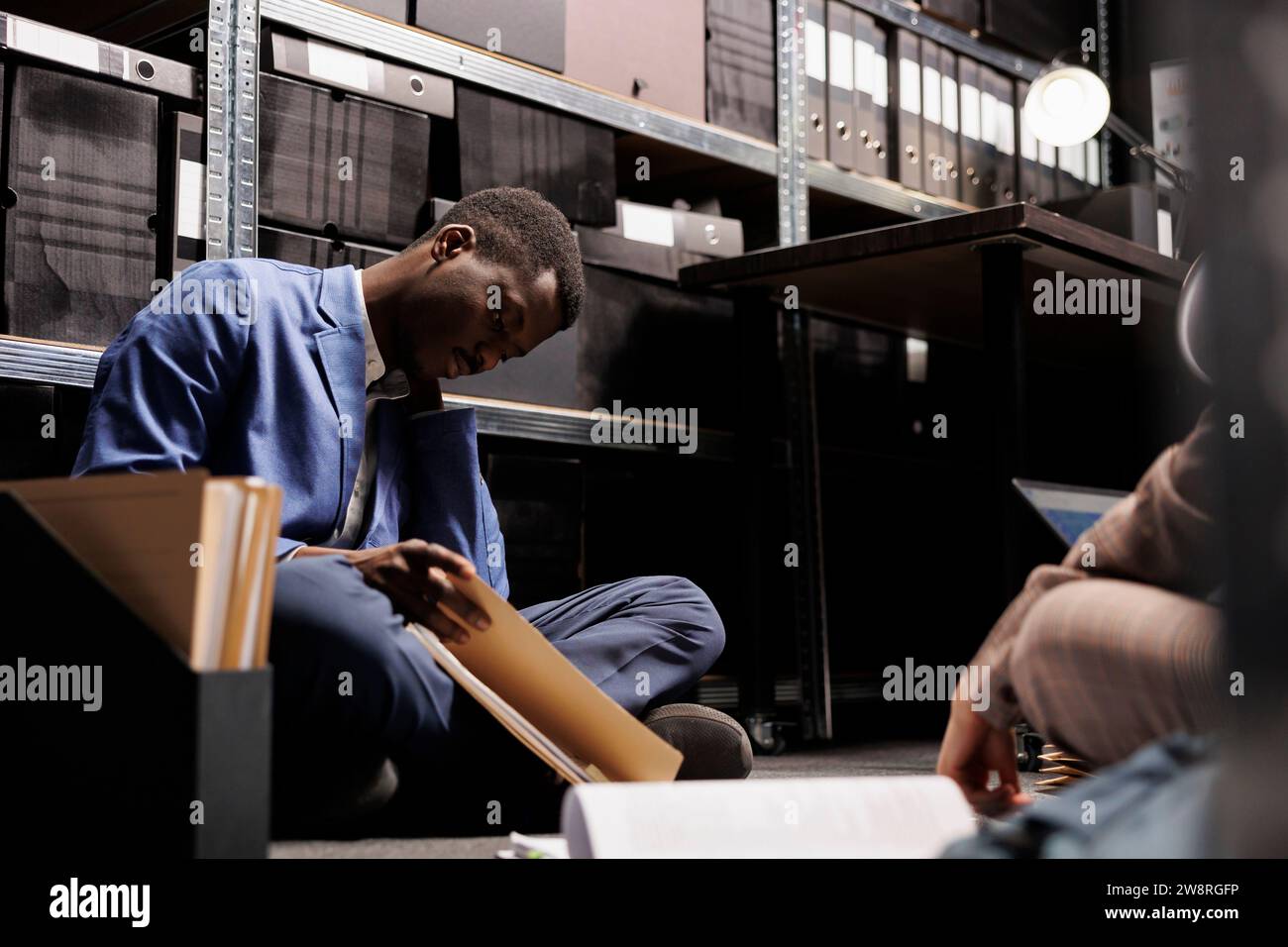 Overworked private investigators discussing case evidence, working late ...